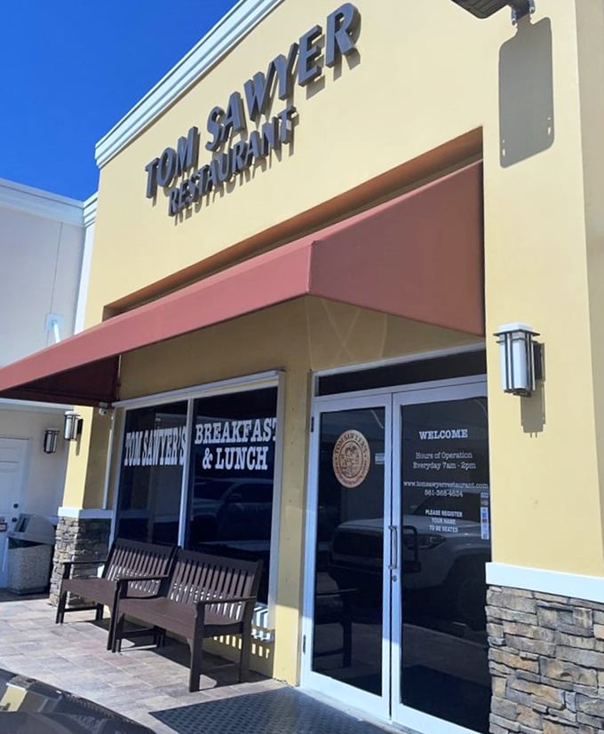 Under Florida's blue sky, this unassuming entrance has welcomed more breakfast enthusiasts than most concert venues. The red awning promises deliciousness.