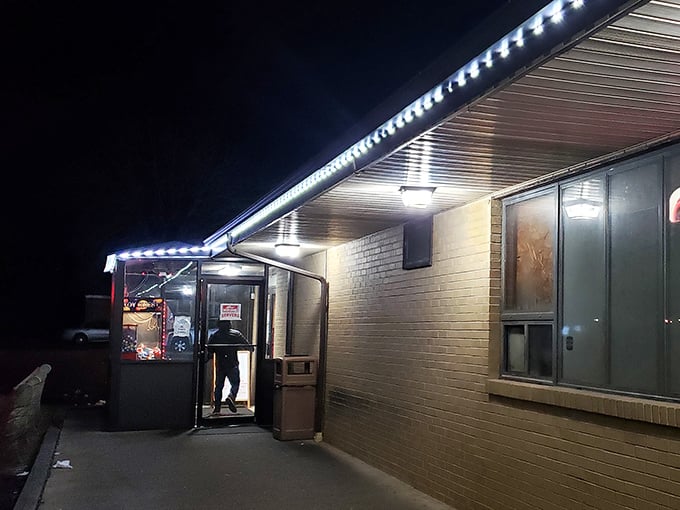 As night falls, the illuminated entrance beckons like a lighthouse guiding hungry sailors to safe harbor.