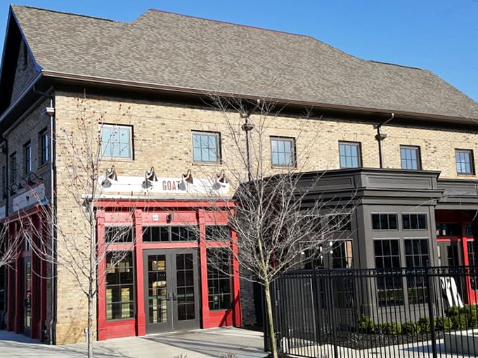 Morning light showcases the architectural details that make The Goat stand out. Those red doorframes aren't just entrances—they're portals to flavor town.