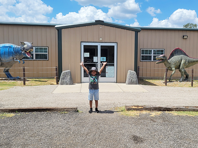 "Mom, I'm home!" A young explorer celebrates his arrival at dino paradise, flanked by prehistoric guardians with toothy grins.