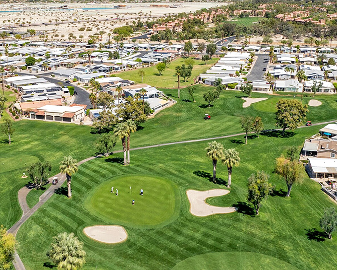 The golf course weaves through the community like a green ribbon, tying together homes where the living is as easy as the dress code.