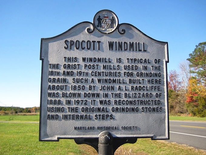 History etched in stone: This marker reveals the windmill's fascinating journey from 1850s original to 1970s reconstruction, complete with authentic grinding stones. 