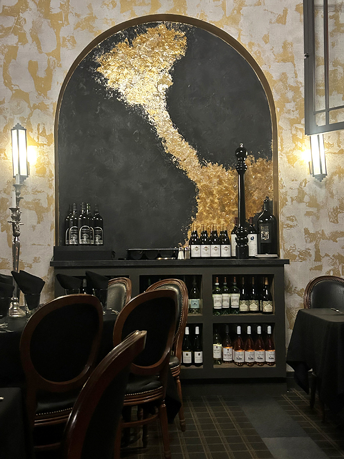 Dramatic gold-accented alcoves showcase wine bottles like the treasures they are. Michelangelo would approve of this ceiling-to-floor artistry.