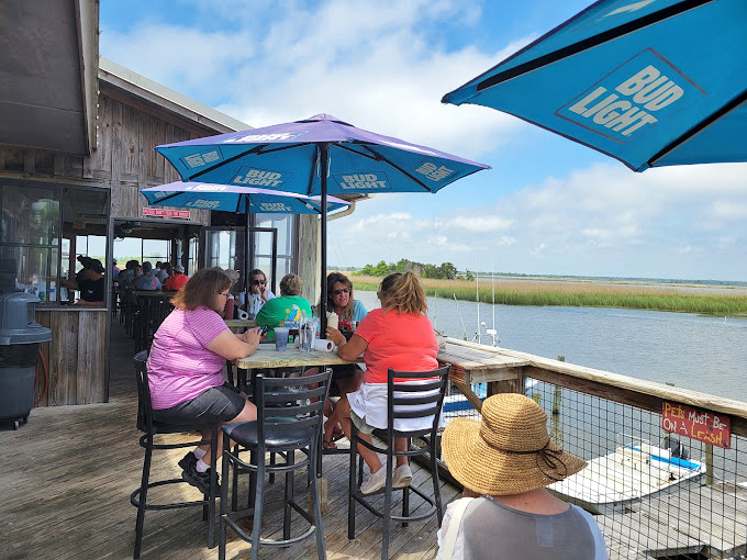 Dining waterside under Bud Light umbrellas with marshland views&mdash;proof that the best restaurant patios aren't designed by architects but by nature herself.