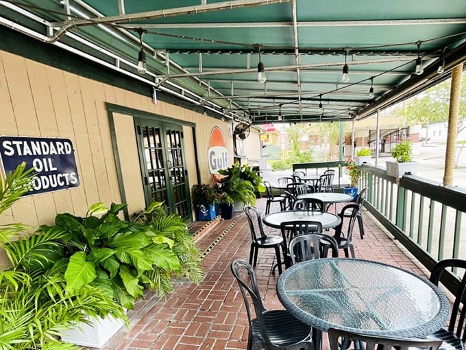 The outdoor dining area offers a plant-lined oasis where string lights twinkle overhead and vintage signs remind you of simpler times.