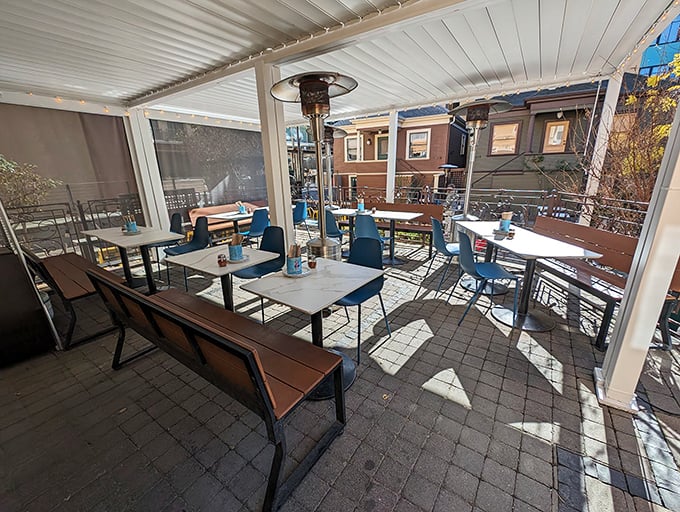The outdoor dining area offers sunshine with your slices&mdash;blue chairs and wooden tables creating an al fresco extension of Rose's pizza paradise.