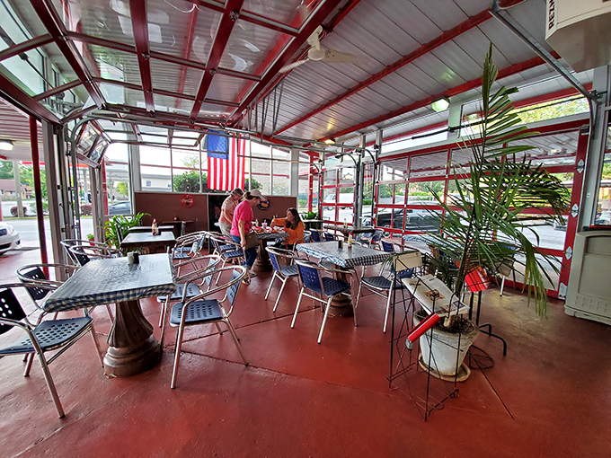The outdoor seating area, complete with American flag and potted plants, offers al fresco dining with a side of small-town charm.