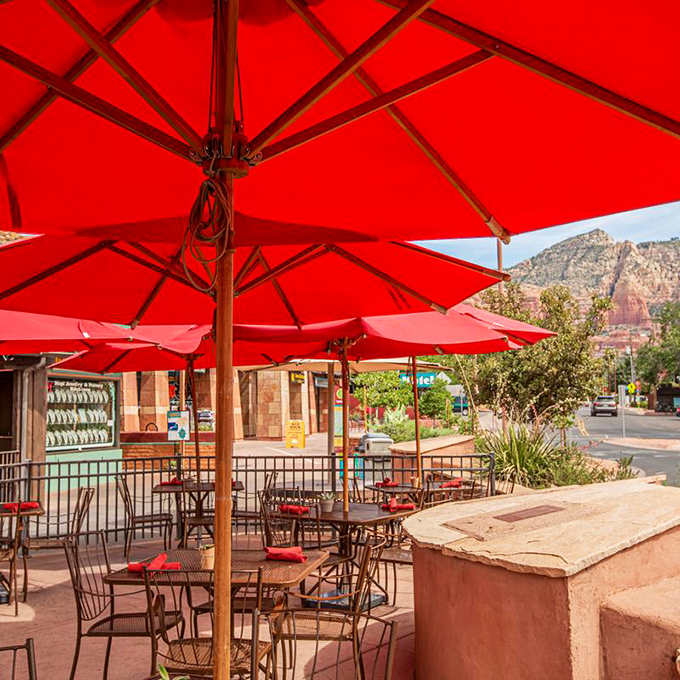 Red umbrellas frame red rocks on the patio, where the Arizona breeze carries the scent of mesquite and the promise of memorable meals.