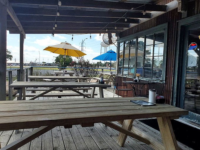 Picnic tables under Texas sky with colorful umbrellas standing guard&mdash;outdoor dining that reminds you why eating should always be this uncomplicated.