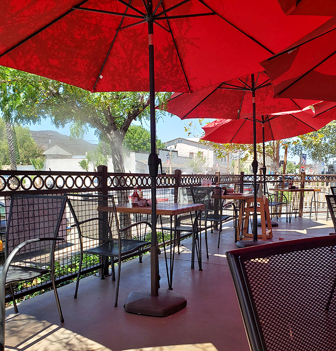 The outdoor patio, shaded by cherry-red umbrellas, offers the perfect setting to enjoy your meal while soaking up that glorious Temecula sunshine.
