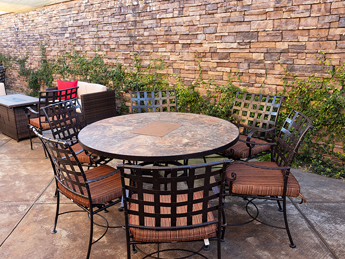 The outdoor patio offers al fresco dining against a rustic stone backdrop—perfect for those magical California evenings when the temperature is just right.