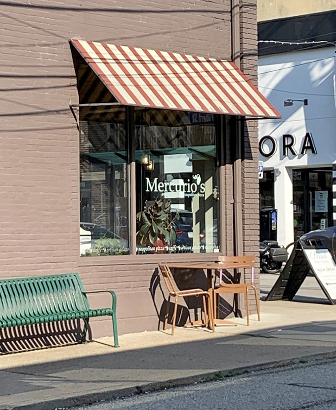 The sidewalk seating offers prime people-watching with your pizza. That green bench is saying, "Come, sit, and watch Pittsburgh life unfold between bites."