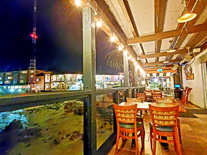 As night falls, the outdoor deck transforms into a twinkling wonderland where the lights of Cannery Row compete with the stars above.
