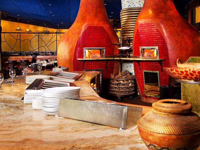 Those magnificent wood-fired ovens working overtime to create flavors you simply cannot replicate at home.