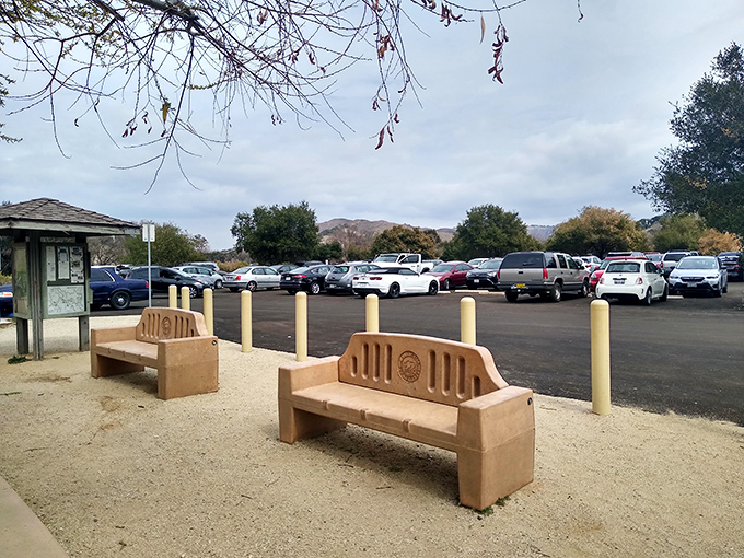 The journey begins at this unassuming parking area. Don't let the ordinary entrance fool you&mdash;extraordinary adventures await just beyond those mountains.