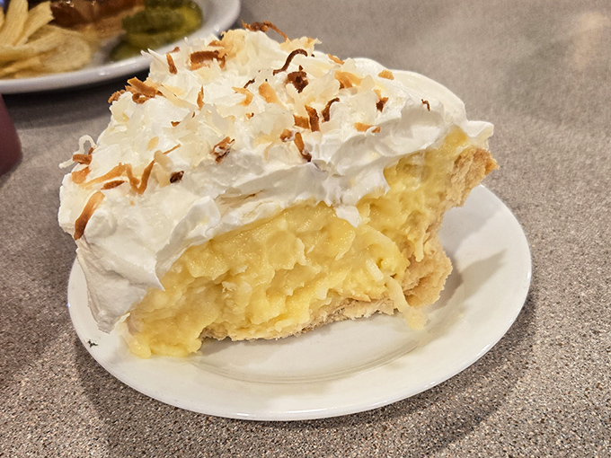 Coconut cream pie that deserves its own zip code – cloud-like meringue, velvety filling, and a crust that shatters perfectly with each forkful.