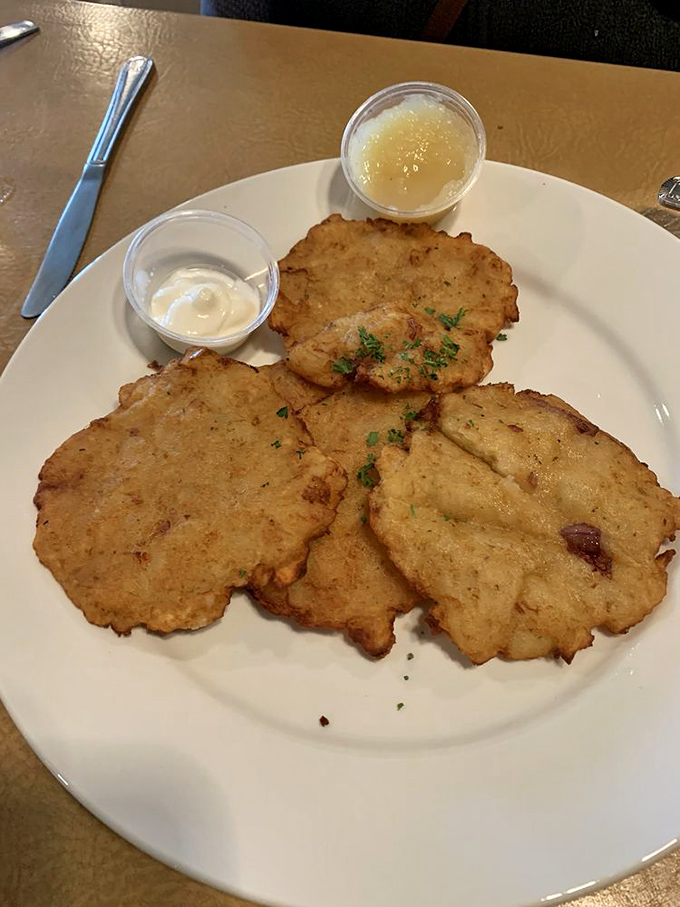 Potato pancakes that could start a family feud—crispy edges, tender centers, and two dipping options because sometimes life shouldn't force you to choose.