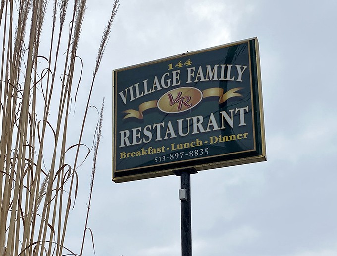 The roadside sign stands tall, a beacon for hungry travelers. Like a lighthouse guiding ships to safe harbor, it guides empty stomachs to fulfillment.
