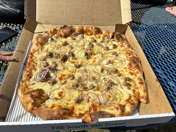 A sausage and onion pizza that would make an Italian grandmother weep with joy. The bubbled crust tells the story of perfect fermentation and serious heat.