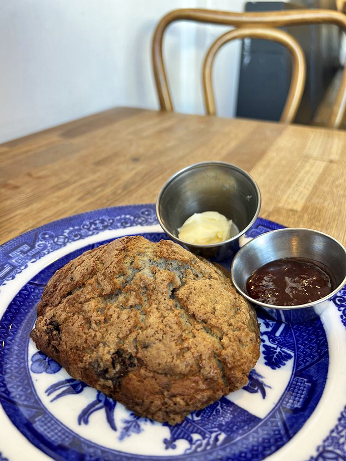 This isn't just a scone; it's a testament to butter's magic. Served on that blue willow plate with jam and butter companions, it's the breakfast equivalent of a warm hug.
