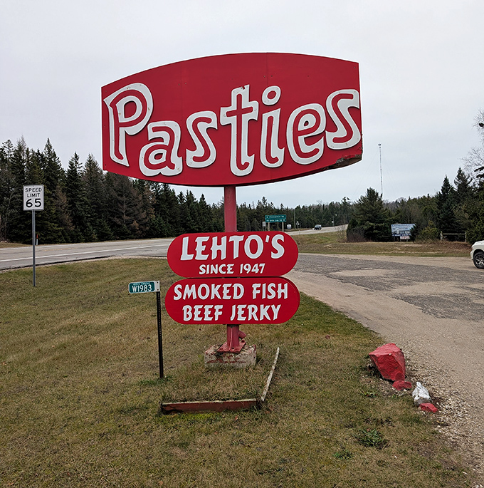 The roadside sign that's saved many a hungry traveler from despair, standing tall against the northern Michigan sky like a beacon of comfort food.