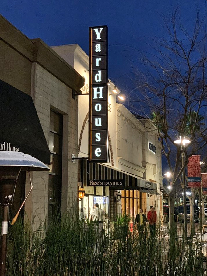 As night falls, the Yard House sign glows like a beacon for those seeking refuge from mediocre meals and uninspired drink lists.