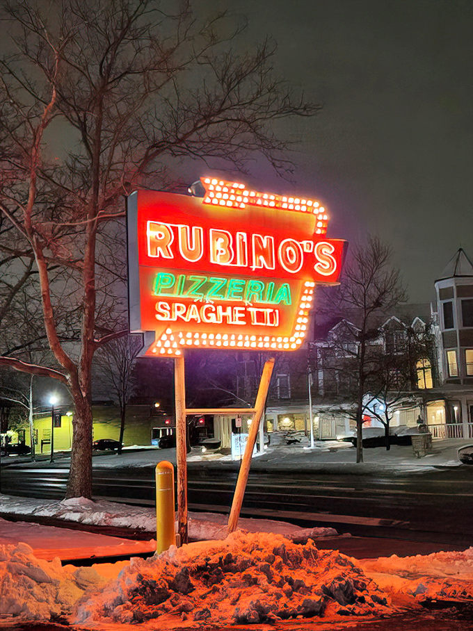 The vintage neon sign cuts through winter darkness, a beacon of hope that says, "Yes, there is joy in this world, and it's shaped like pizza."