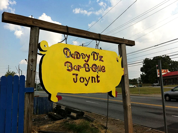 Yellow pig sign beckoning from the roadside &ndash; like a BBQ lighthouse guiding hungry travelers to smoky salvation.