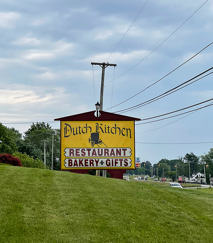 The roadside sign promises three essential food groups: restaurant, bakery, and gifts. Two feed your body, one feeds your soul.