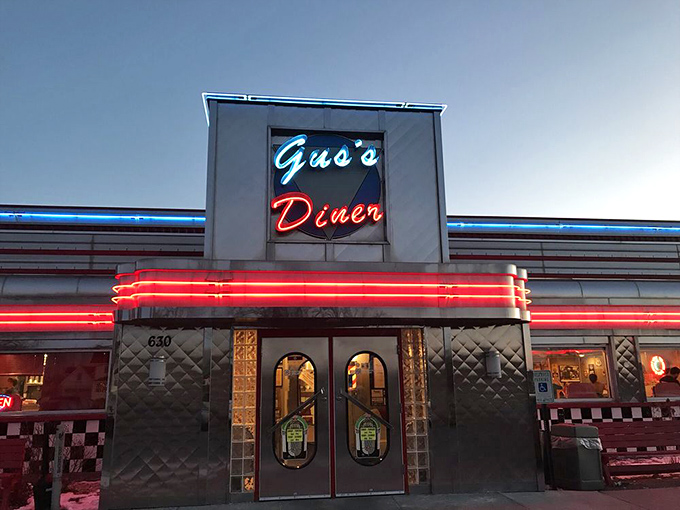 As night falls, Gus's neon sign glows like a beacon for hungry travelers &ndash; a promise of comfort food that transcends time in Sun Prairie.