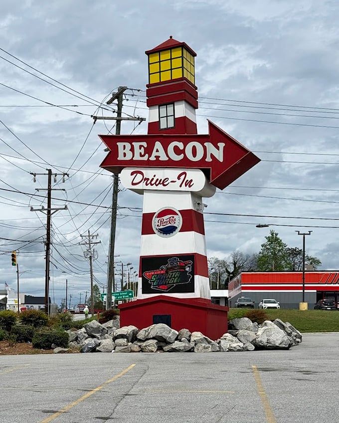The lighthouse-inspired sign stands tall like a beacon (pun absolutely intended) guiding hungry travelers to burger nirvana since before GPS was a thing.
