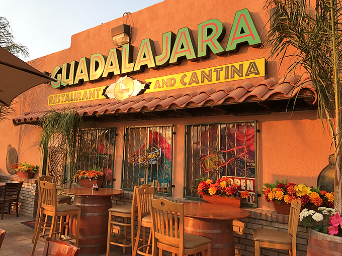 The sign glows like a beacon at dusk, promising authentic flavors and hospitality that chain restaurants can only dream of replicating.