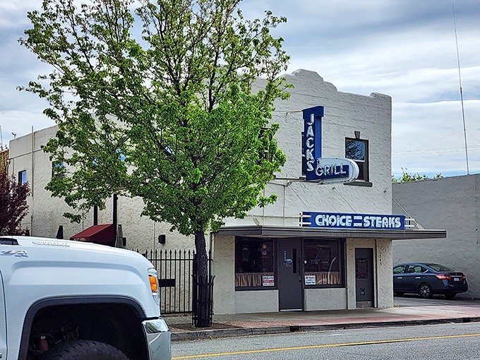 Jack's Grill stands proudly on the street, its white walls and blue signage a landmark for those seeking the timeless pleasure of a perfectly cooked steak.