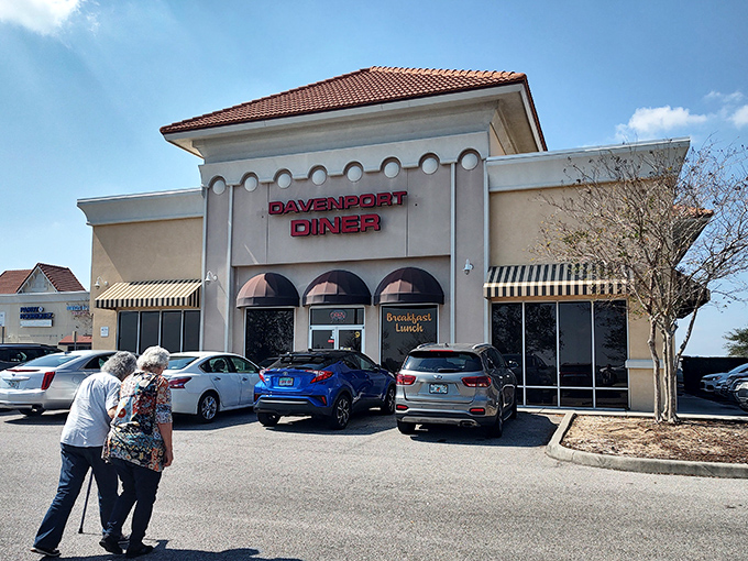 Two patrons approach their breakfast destiny, drawn by the magnetic pull of those red letters and the promise of eggs cooked exactly how they like them.