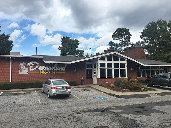The storefront on a blue-sky day, promising that inside those brick walls, time slows down and barbecue takes center stage.