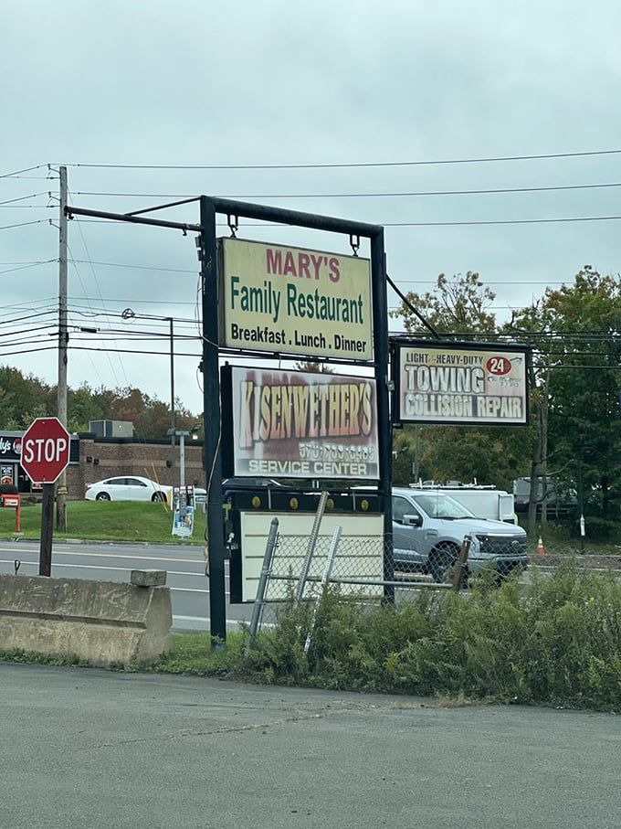 The roadside sign stands as a beacon for hungry travelers, promising three essential meals without any unnecessary fuss or pretension.