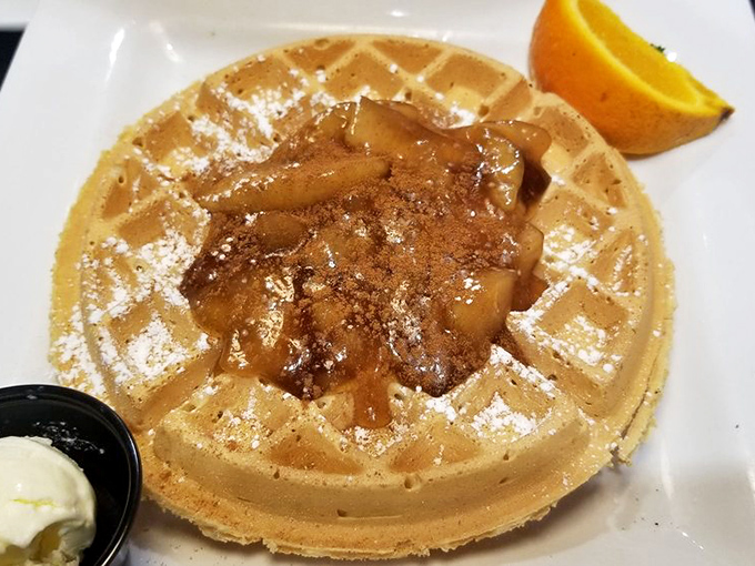 A waffle that's living its best life with a warm cinnamon apple embrace. That orange wedge is just there to witness greatness.