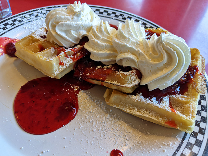Waffles that strike the perfect balance &ndash; crisp exterior, fluffy interior, and topped with whipped cream that melts into the warm strawberry sauce.
