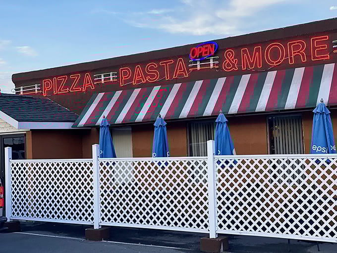 The neon glow of "PIZZA PASTA & MORE" isn't just a sign&mdash;it's a beacon of hope for the hungry traveler. Italian stripes never looked so appetizing!