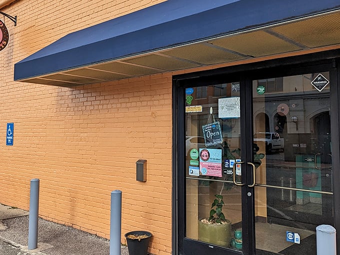 The sunny yellow brick exterior of Glazed Doughnuts beckons like a sweet morning promise. Blue awning, bike-friendly, and bound to brighten your day!
