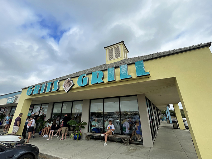 The iconic turquoise sign of Grits Grill beckons hungry beach-goers like a lighthouse for empty stomachs.