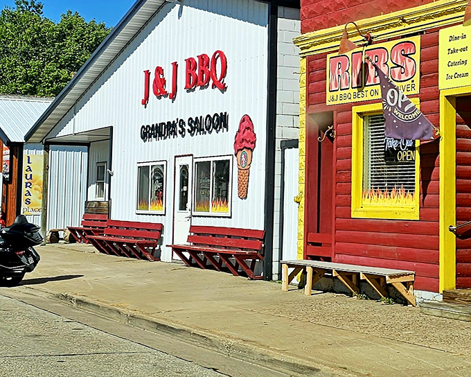 J & J BBQ's white building with red benches is like finding a treasure map where X marks the spot for smoky deliciousness.