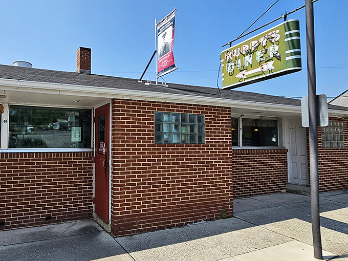 The classic brick exterior of Kuppy's Diner promises comfort food magic within. That vintage sign has been beckoning hungry travelers for generations.
