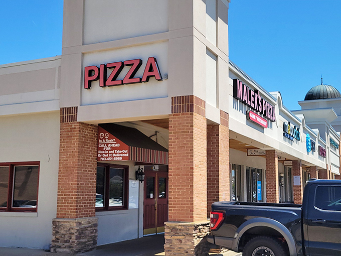 The bright red "PIZZA" sign beckons like a lighthouse for the hungry. Malek's simple storefront hides flavor treasures within.