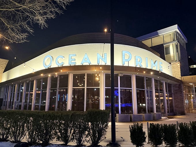 Ocean Prime's glowing blue sign beckons like a lighthouse for seafood lovers. Modern elegance meets maritime magic at this Troy hotspot.