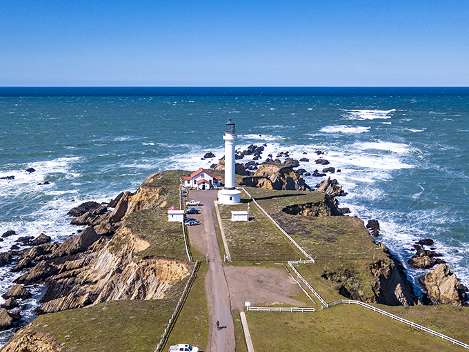 Point Arena Lighthouse stands like a sentinel on its rocky peninsula, where the wild Pacific seems determined to reclaim the land.