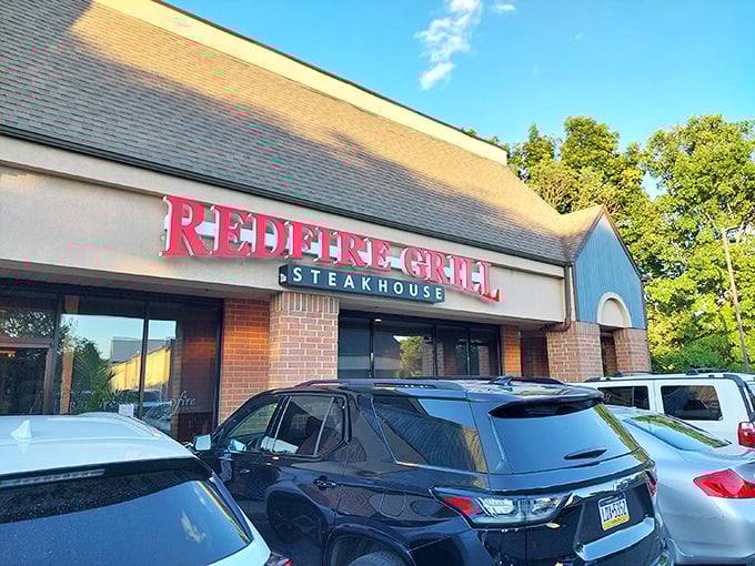 The bold red sign of Redfire Grill beckons like a lighthouse for the steak-obsessed. A suburban sanctuary where prime cuts meet flame.
