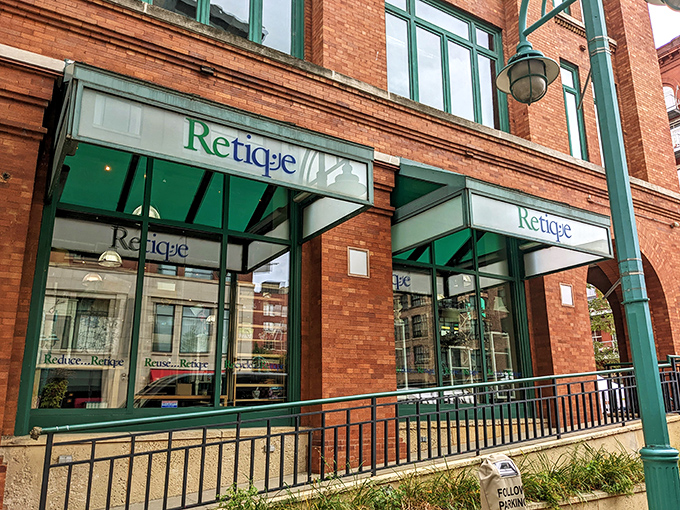 Retique's elegant brick storefront with green awnings invites you in like a fashionable friend saying, "Come see what treasures await inside!"