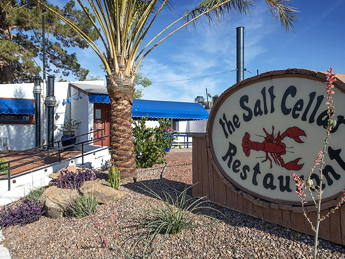The Salt Cellar's iconic sign beckons seafood lovers. This underground treasure brings coastal vibes to the desert with its charming blue awnings.