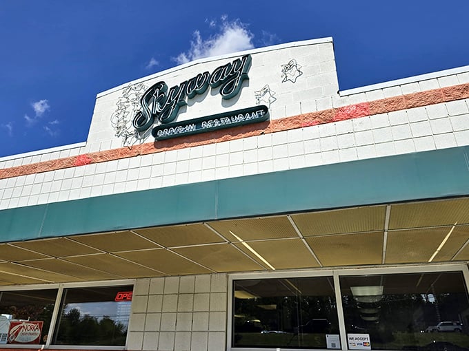 The Skyway Drive-In sign gleams like a beacon from the past, promising burgers that would make your cardiologist wince but your soul sing.